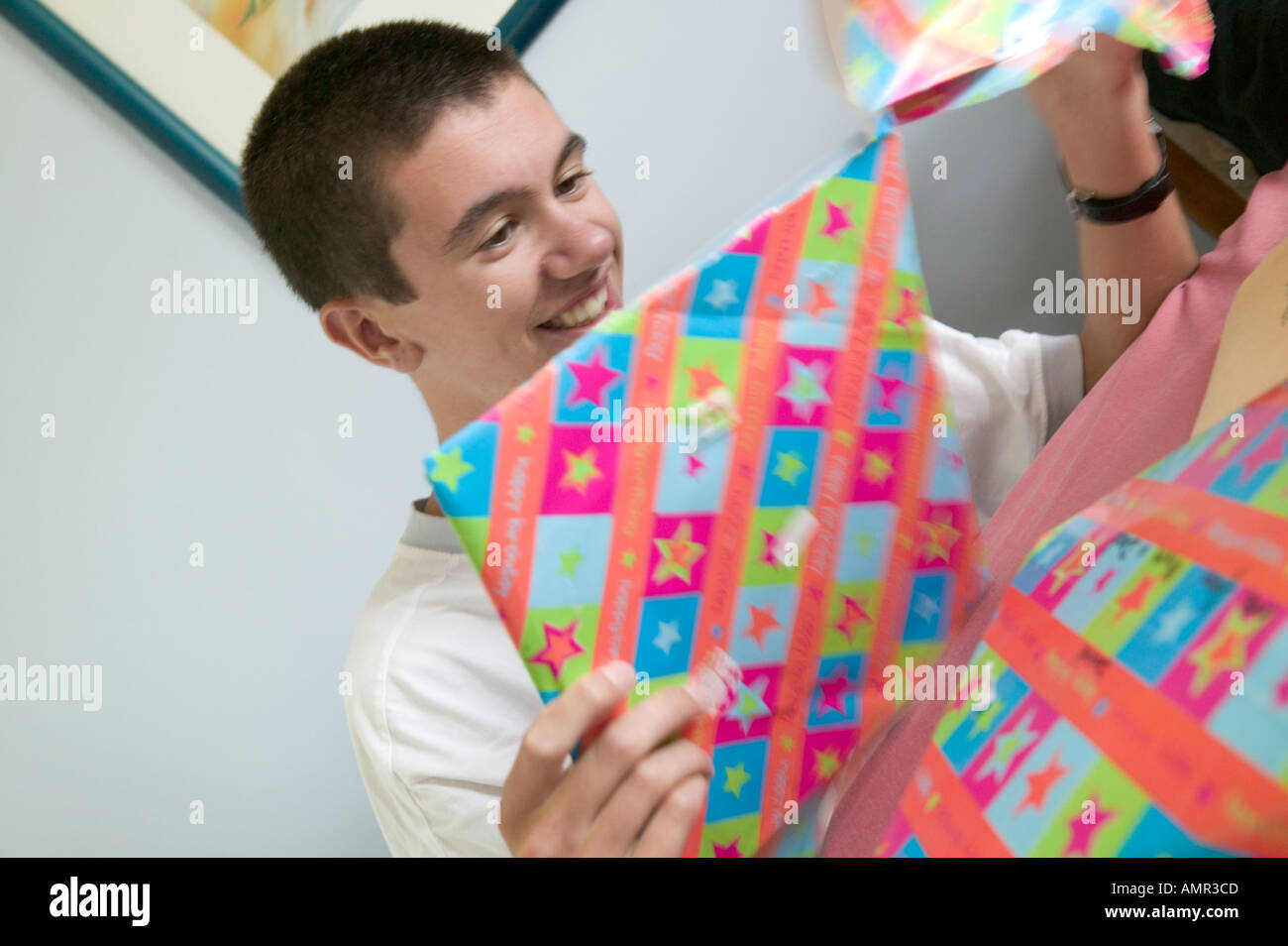 Teenager unwrapping present Stock Photo - Alamy