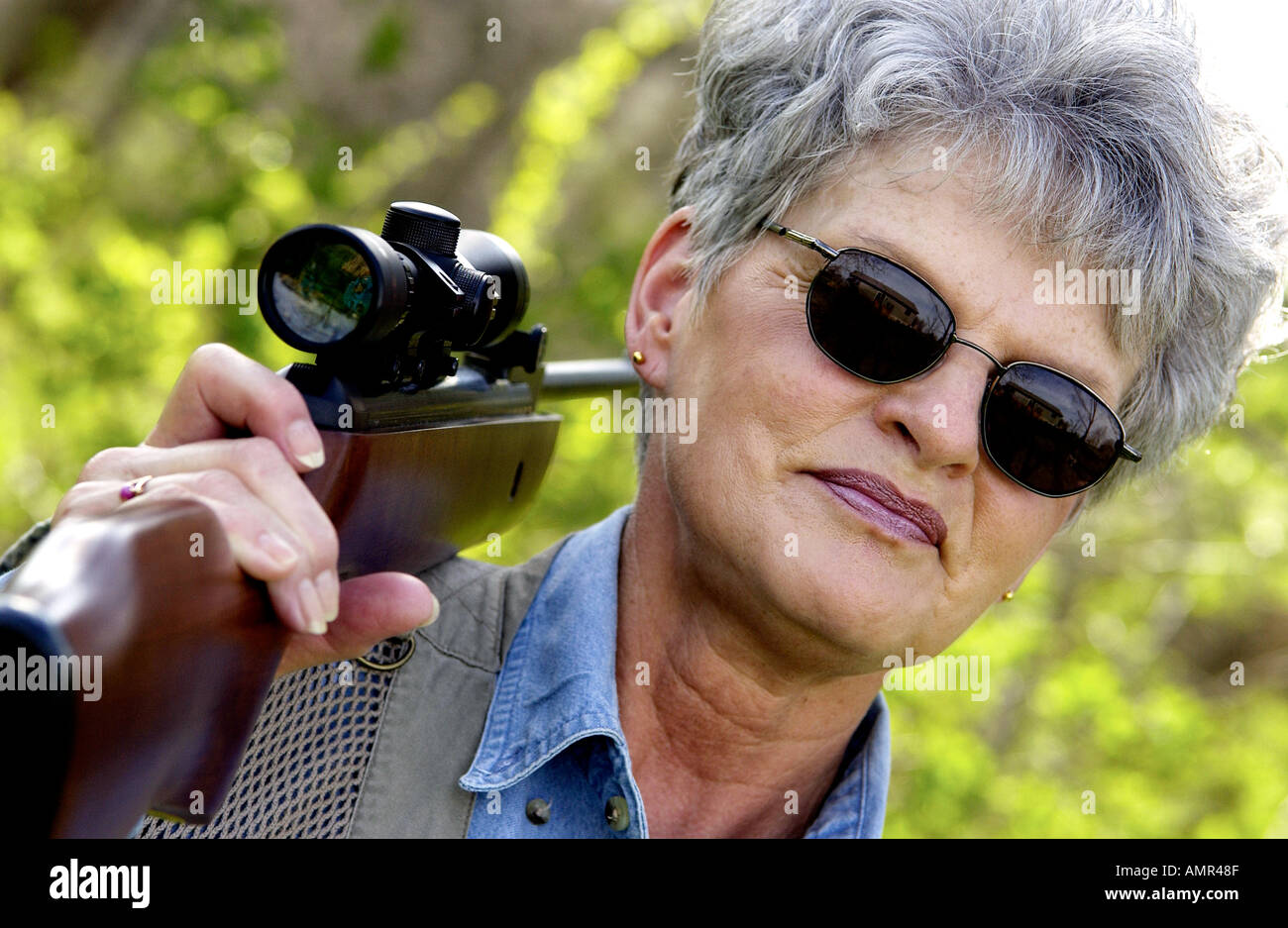 Woman carrying rifle Stock Photo - Alamy