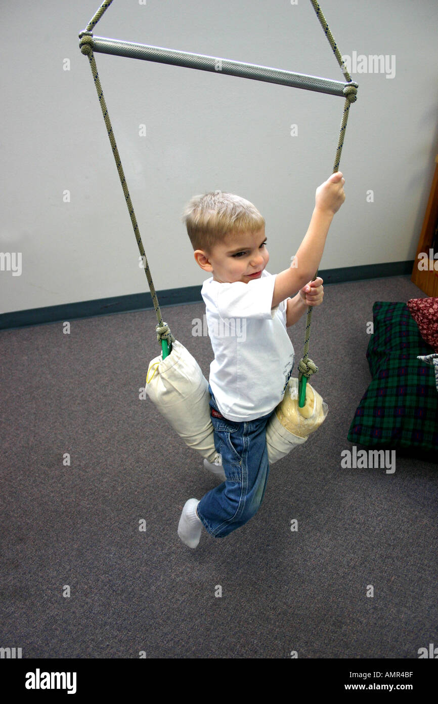 child on swing during occupational therapy session suspended equipment ...