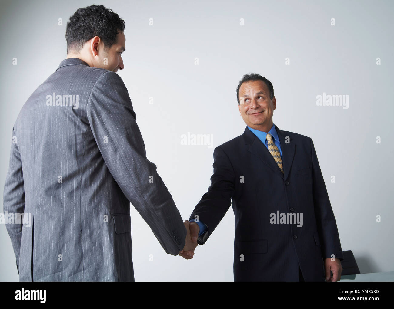 Two mature businessmen shake hands hi-res stock photography and images ...