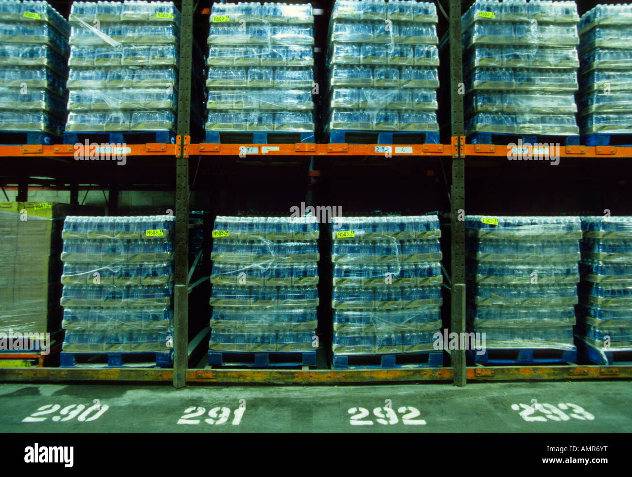 Warehouse storage shelves with stacks of plastic wrapped goods ...
