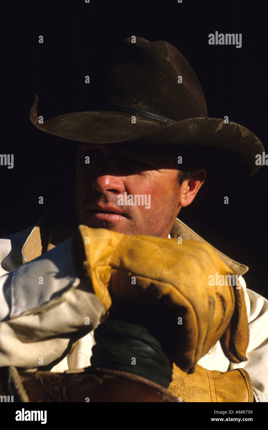 Close up of cowboy with gloved hand on saddle Stock Photo - Alamy