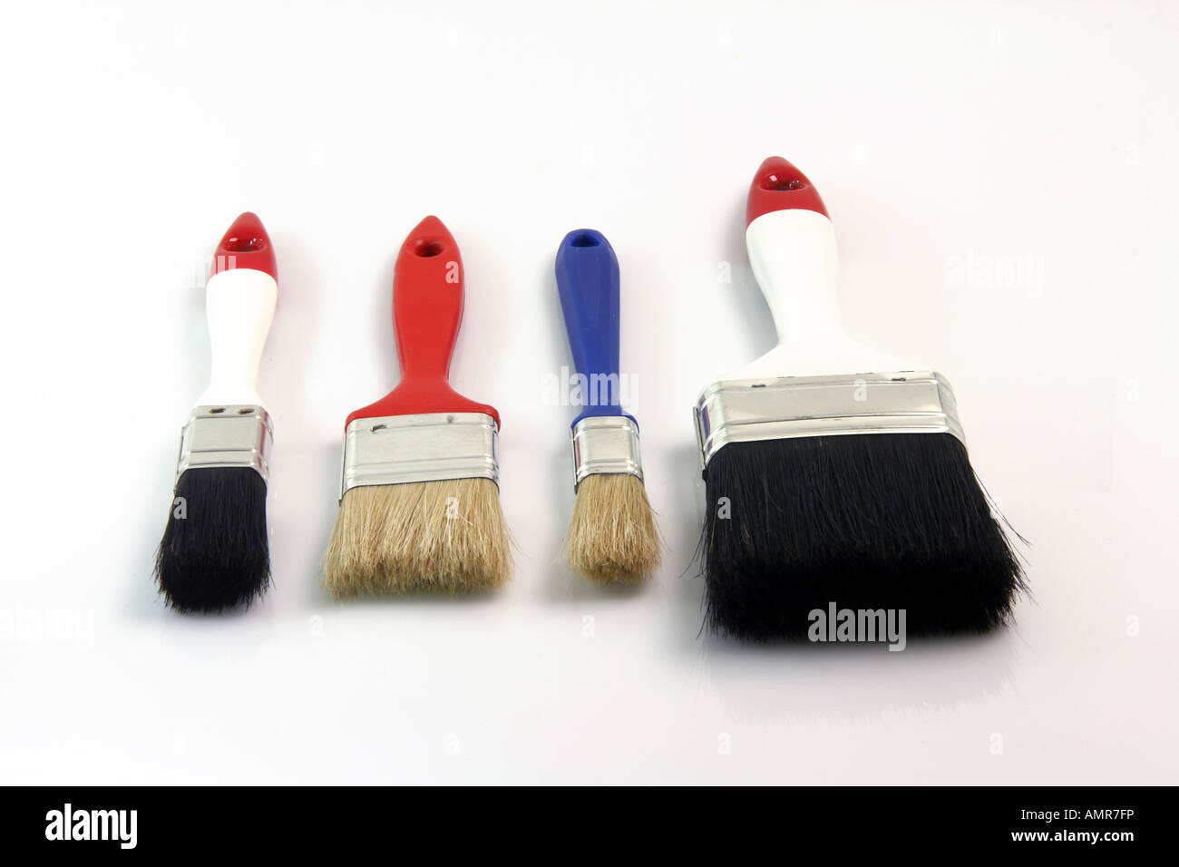 four paint brushes on white background hardware tools Stock Photo - Alamy