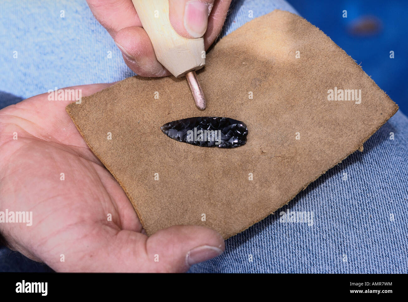 A flintknapping student is working on an arrowhead using the pressure ...