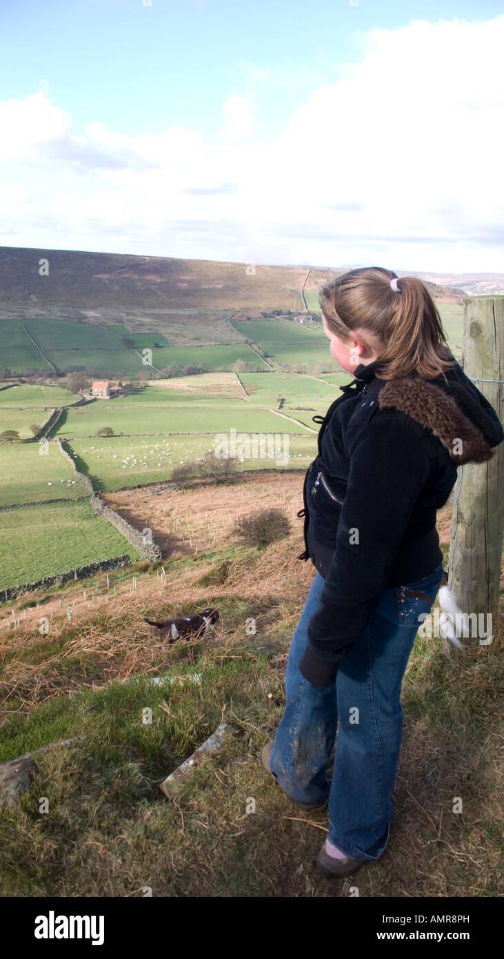 9 year old girl with spaniel dog looking over valley North Yorkshire ...