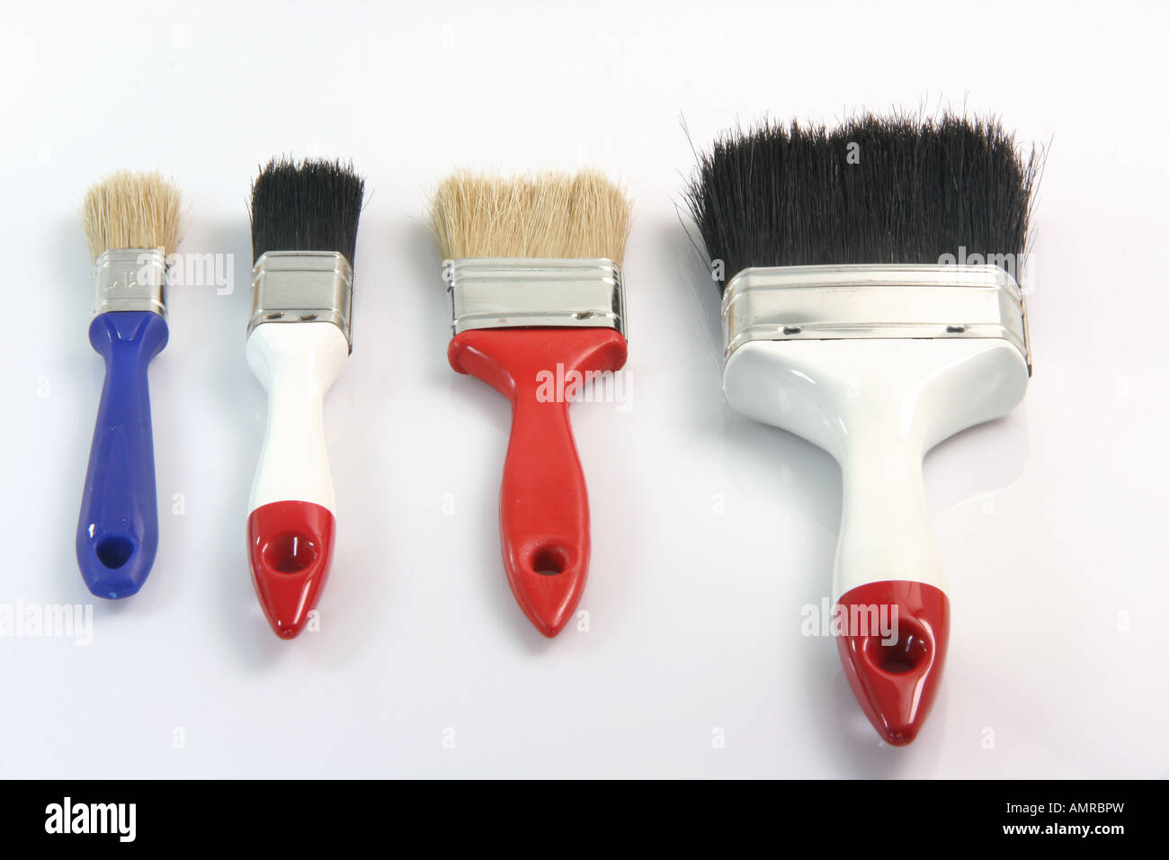 four paint brushes on white background hardware tools Stock Photo - Alamy