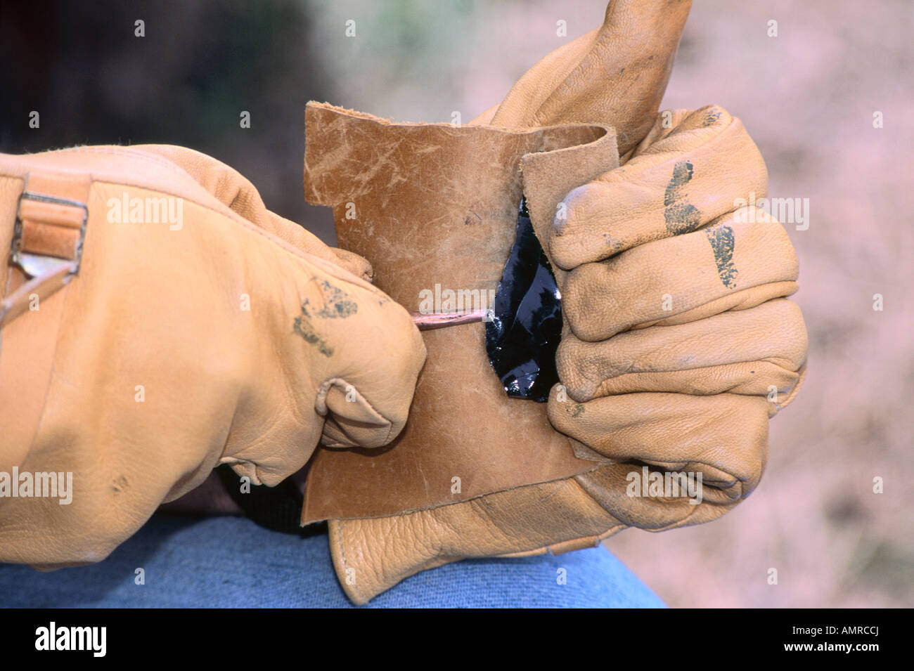 A flintknapping student is working on an arrowhead using the pressure ...