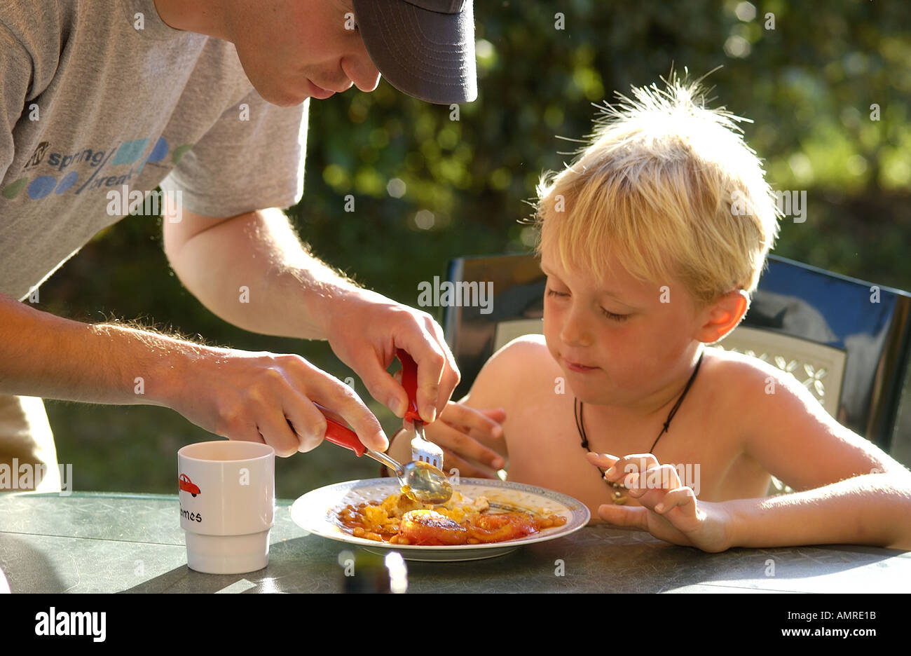 Helping a child to cut up his breakfast Stock Photo - Alamy