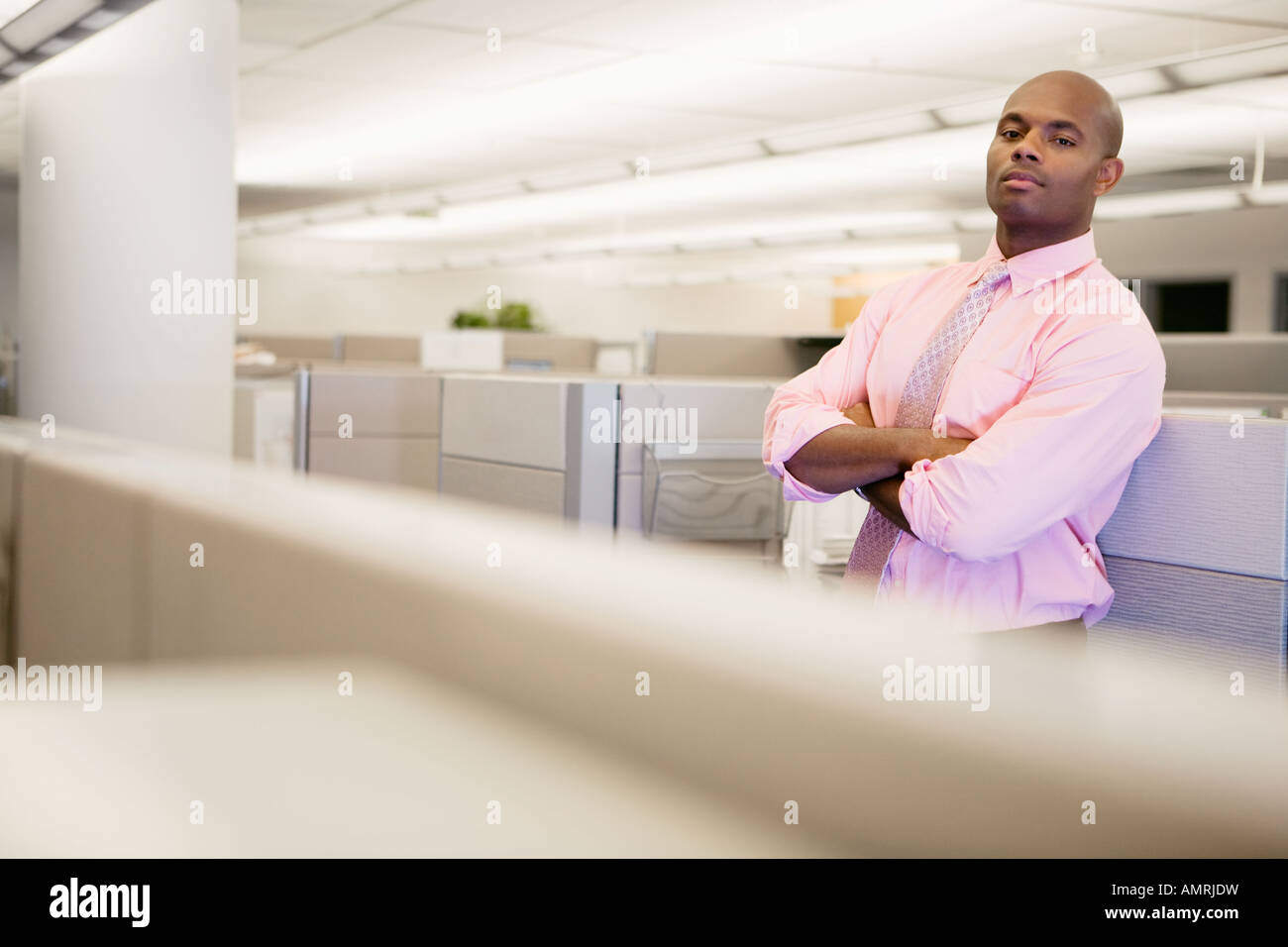 African businessman leaning against cubicle wall Stock Photo - Alamy