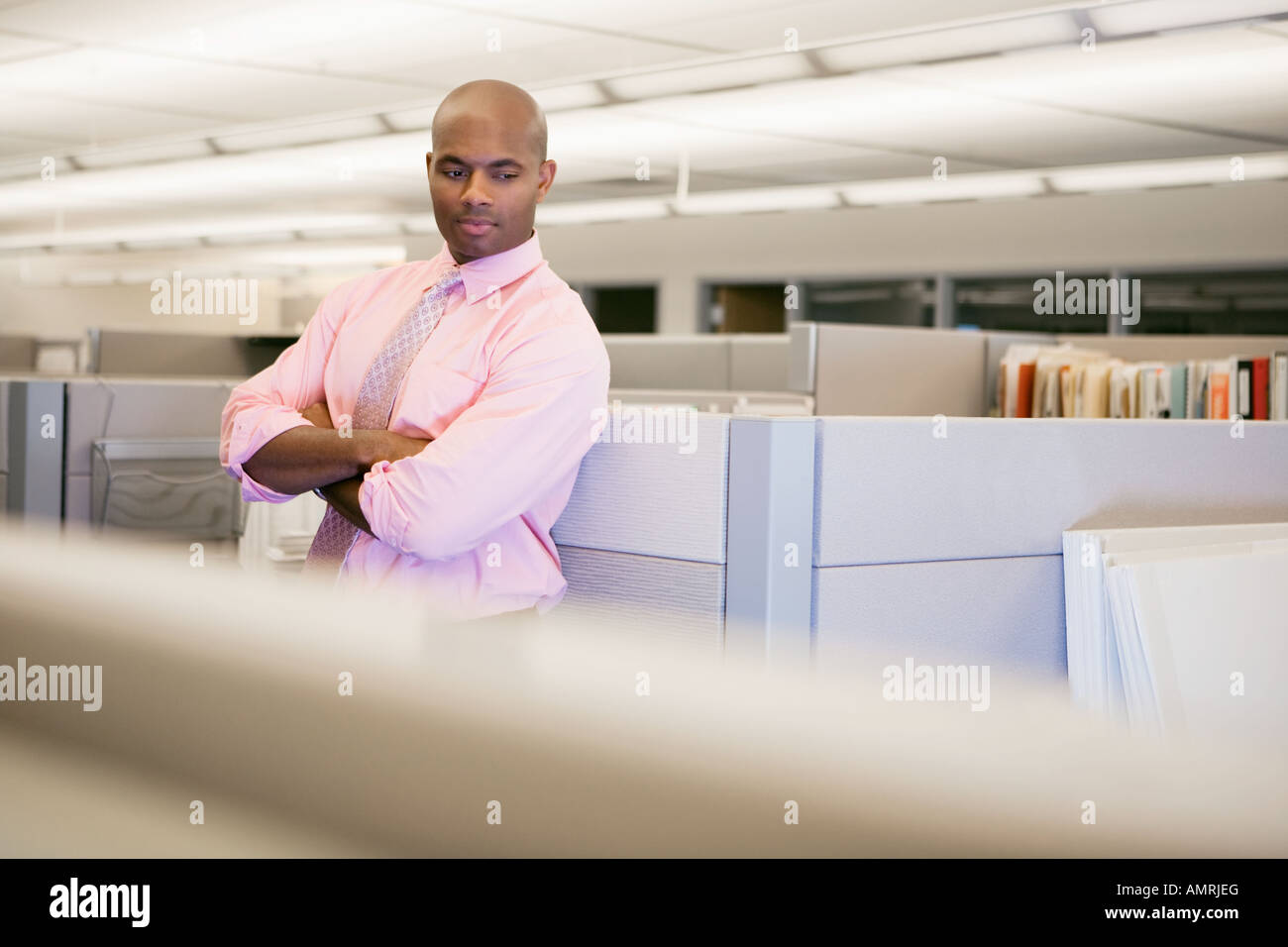 African businessman leaning against cubicle wall Stock Photo - Alamy