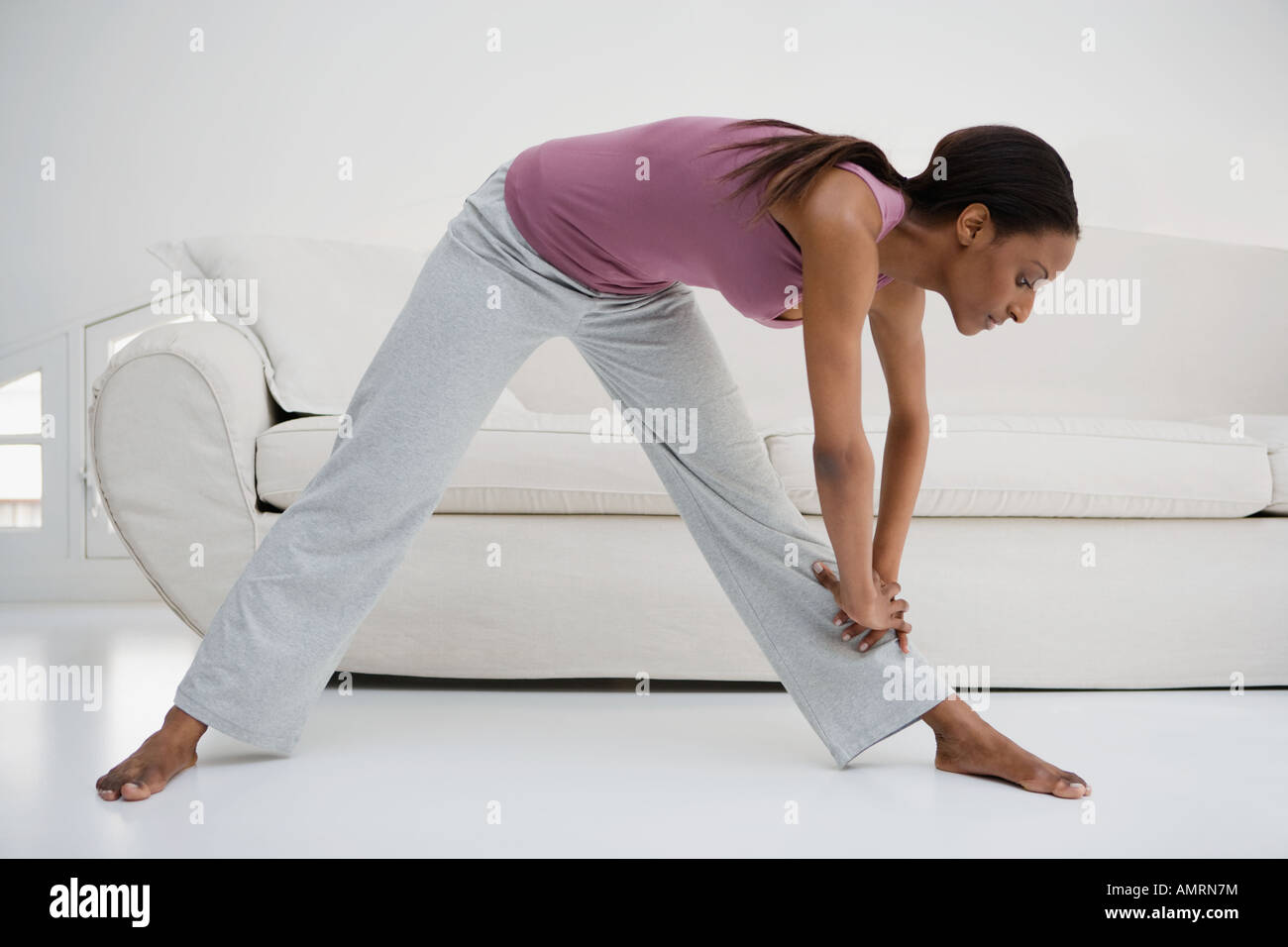 African woman stretching in living room Stock Photo - Alamy