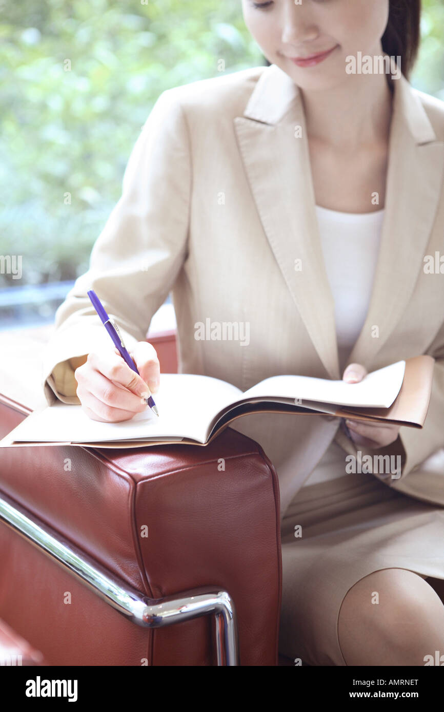 Japanese secretary writing in notebook Stock Photo - Alamy