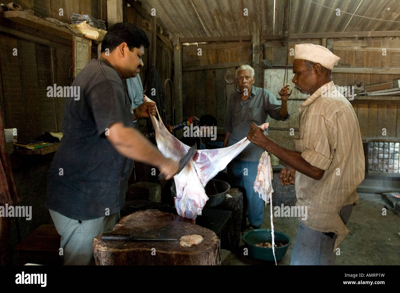 An Indian butcher prepares and cuts a goat to sell in Navsari, Gujarat ...