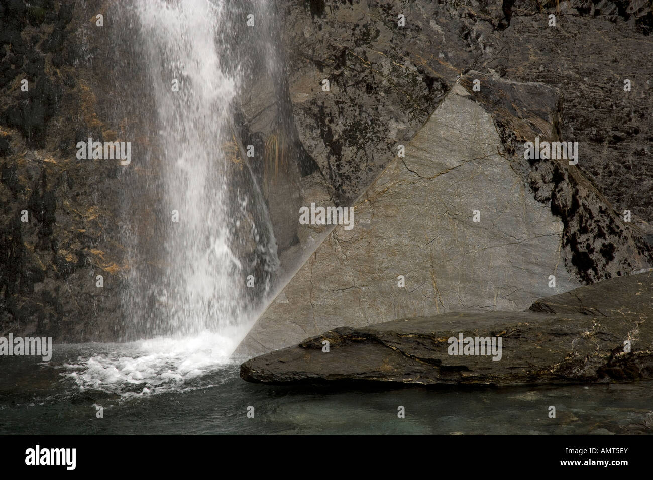 A naturally triangular piece of stone at the base of a waterfall Stock ...