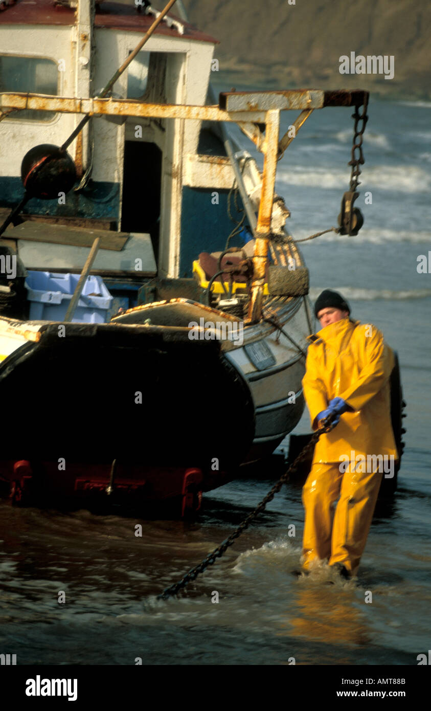 Local fisherman brings a Filey coble ashore North Yorkshire England ...