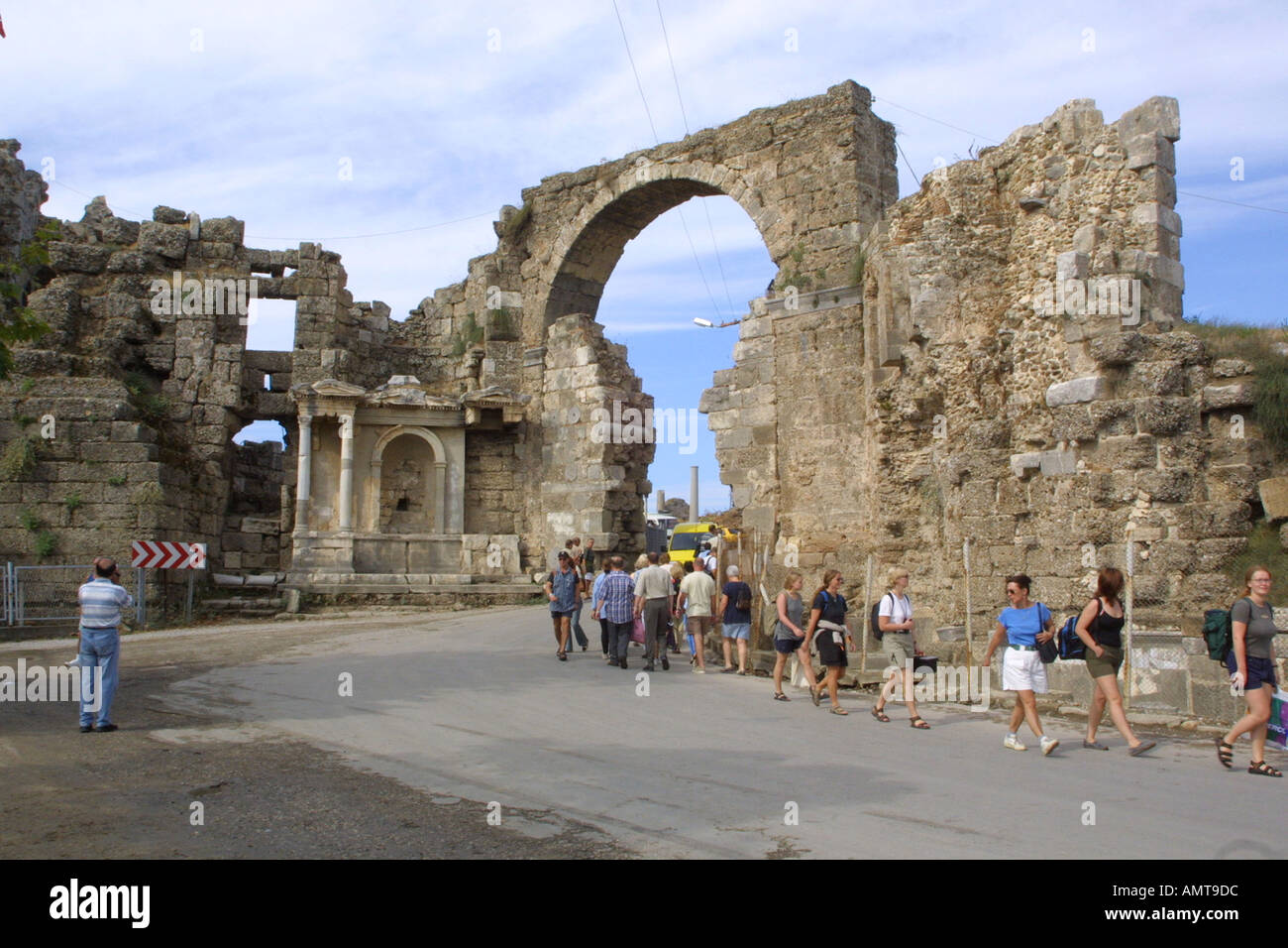 Tourists walk through a Roman arch at the Roman town of Side in Turkey ...