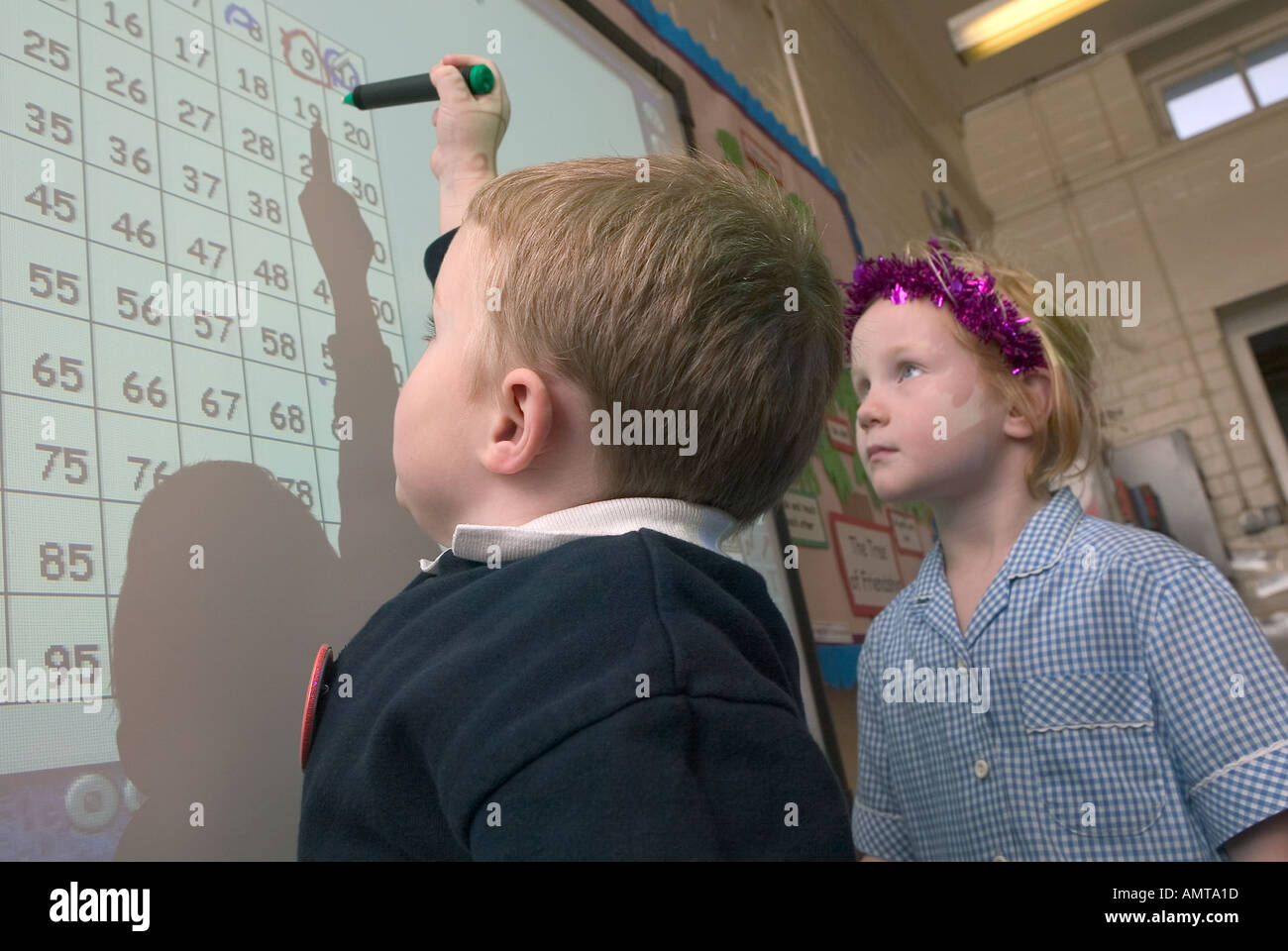 Children using a projection number chart in an infant school classroom ...