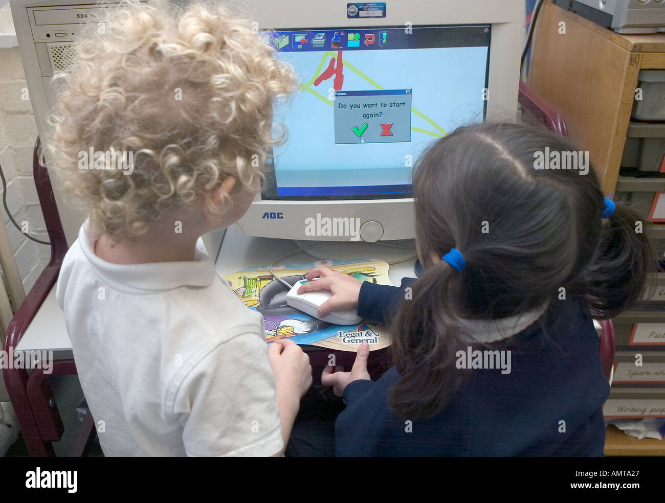 Children using a computer in an infant school classroom in England ...