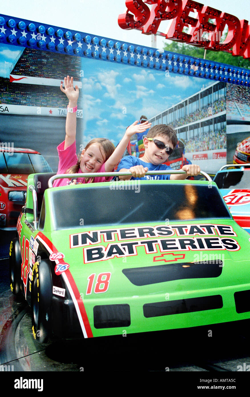 5 year old girl and brother ride race cars at a carnival 2 Stock Photo ...