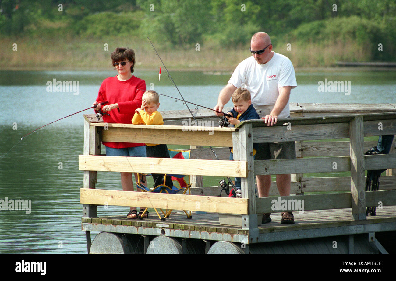 DM Young family of 4 fish off the end of a pier Stock Photo - Alamy