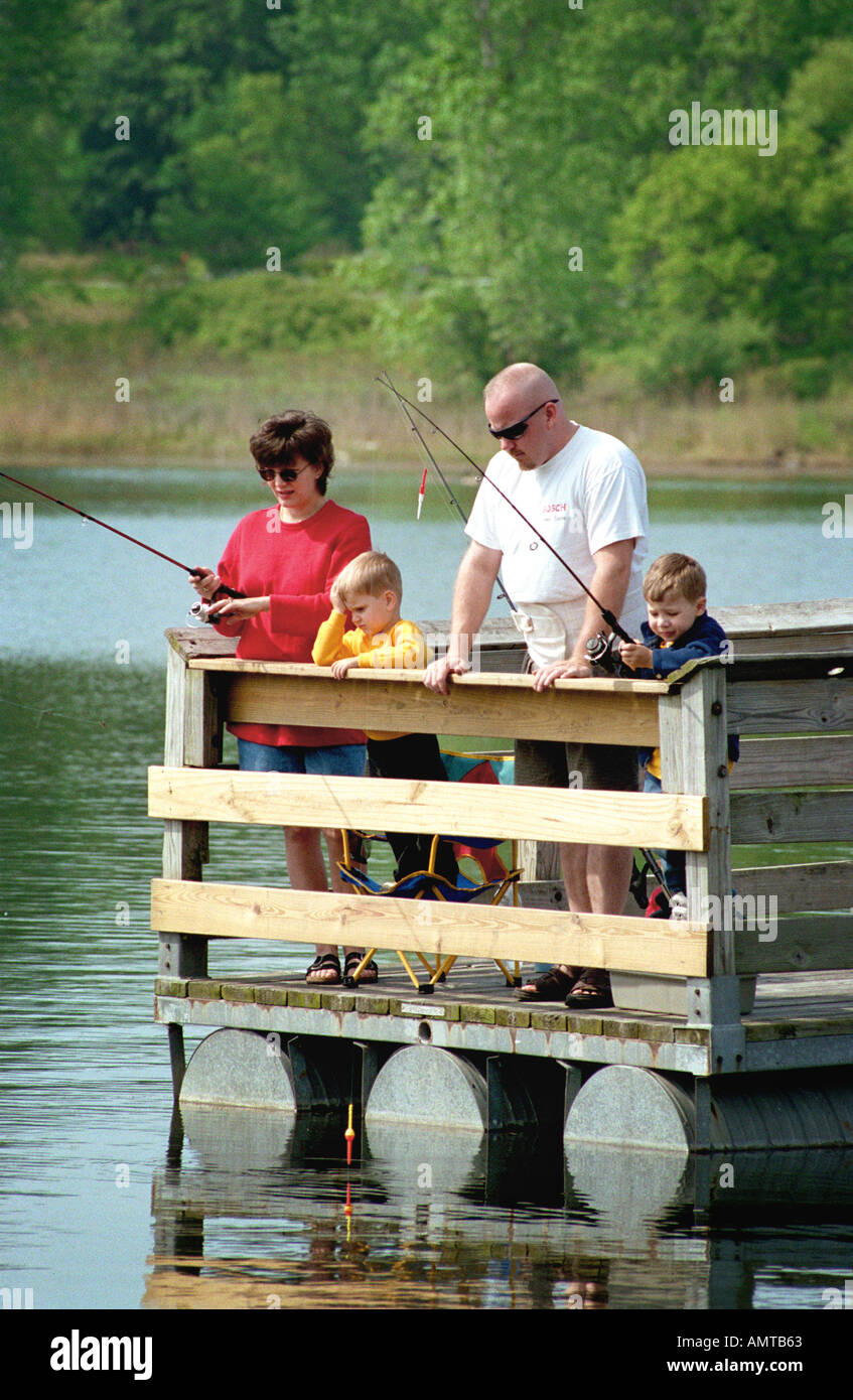 Young family of 4 fish off the end of a pier Stock Photo - Alamy