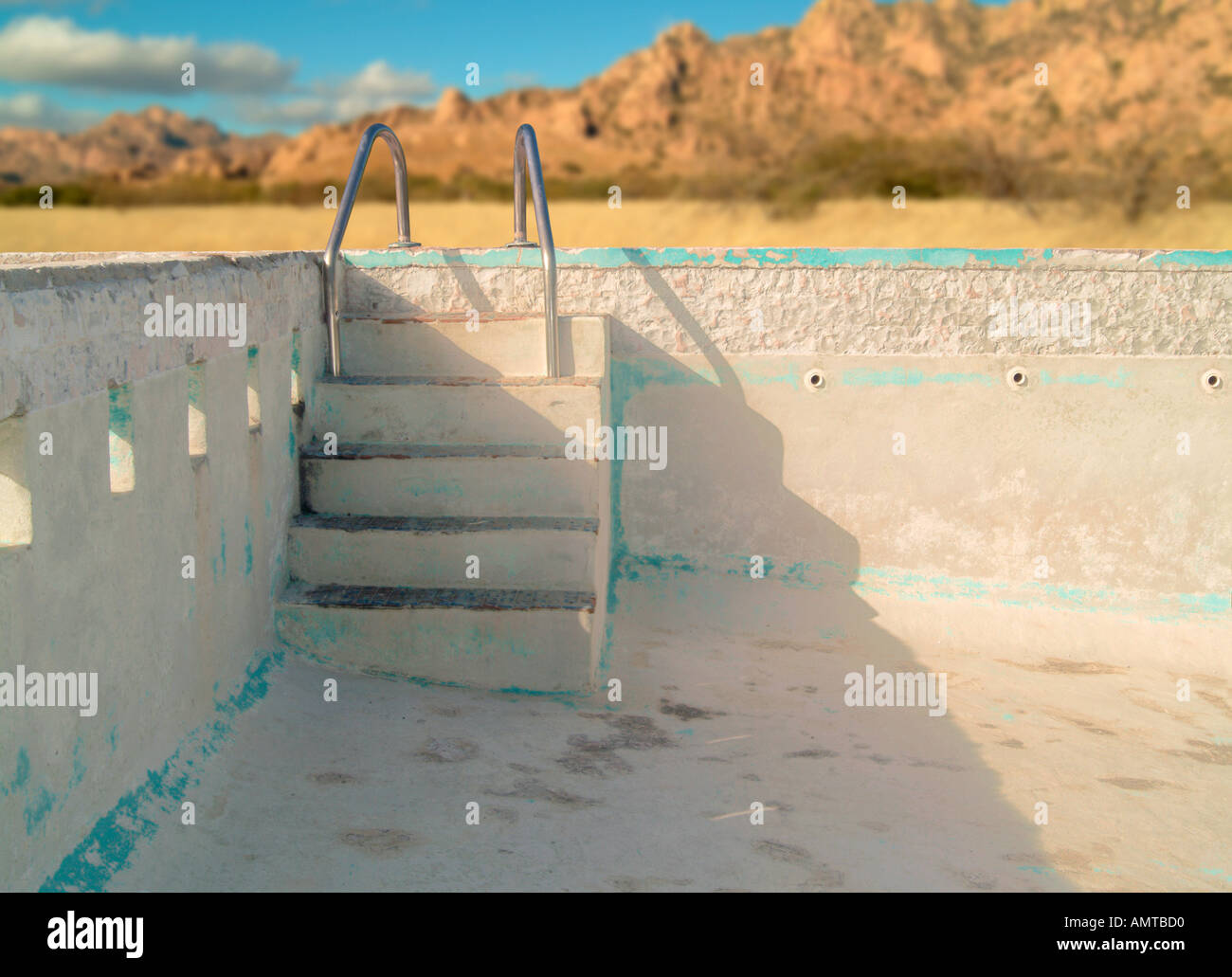 an empty concrete swimming pool with steps leading down into the pool ...