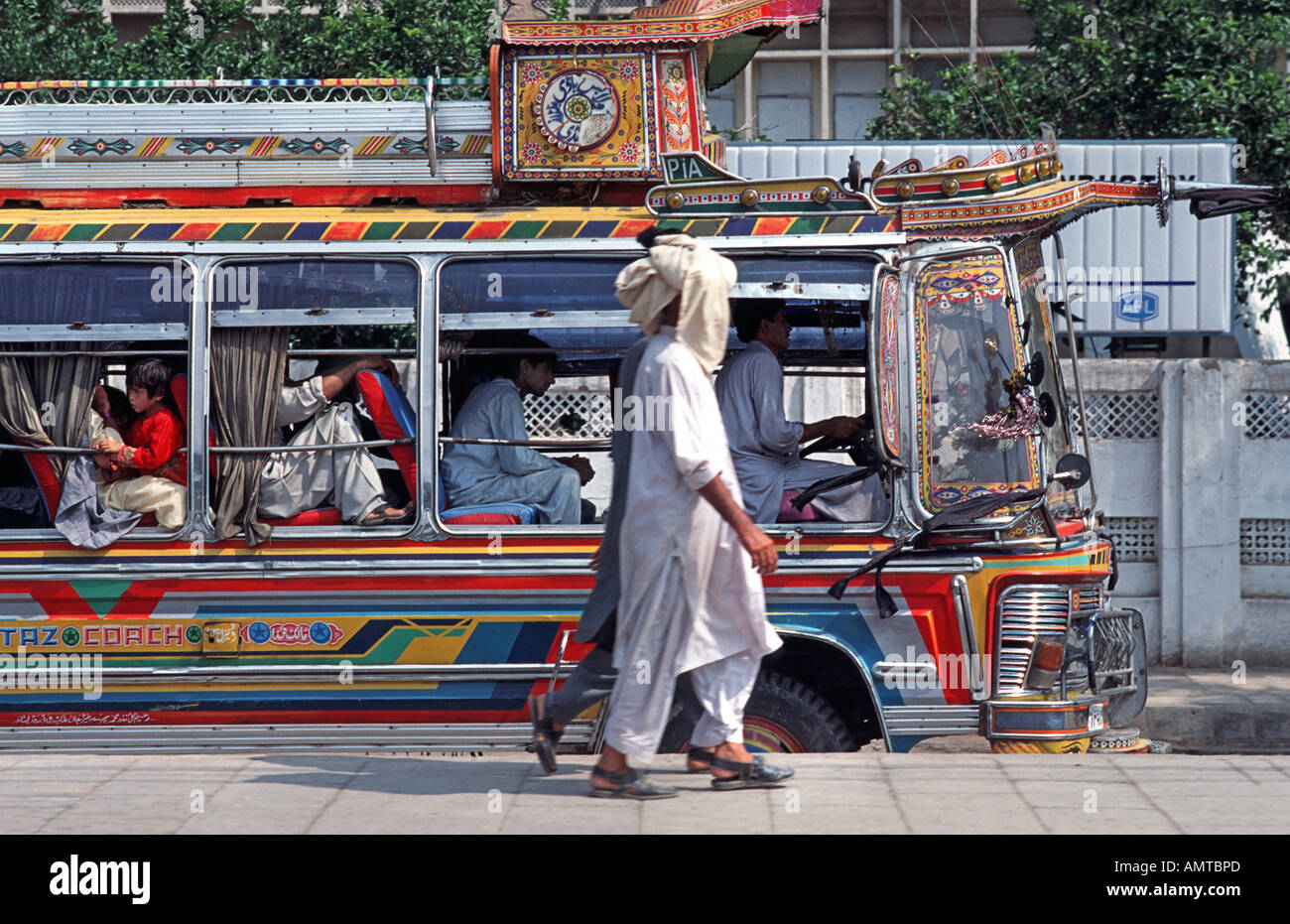 Urban street scene Pakistan Pedestriansbeing passedby a local bus on ...