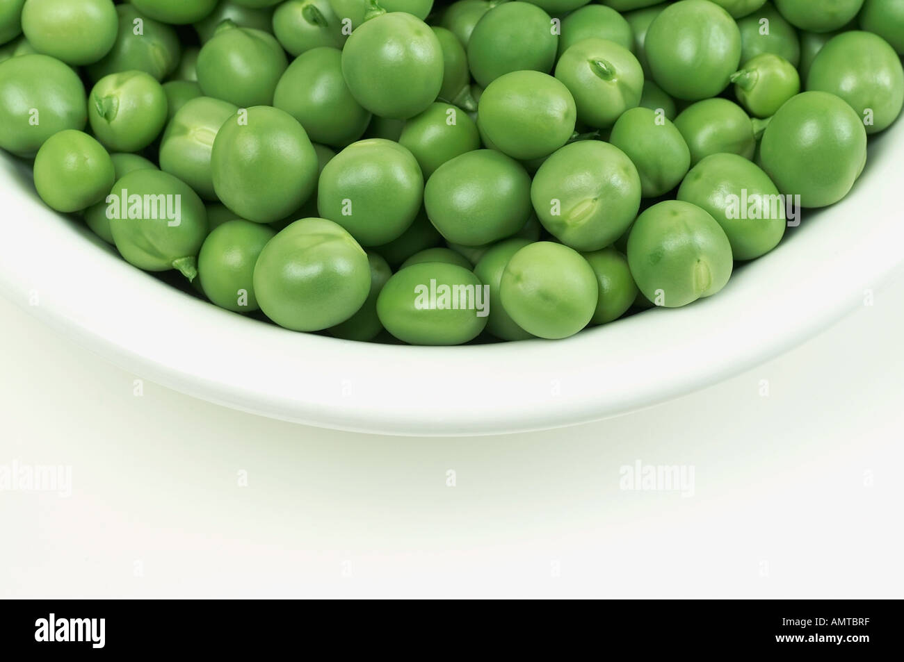 Bowl of peas on white background Stock Photo - Alamy