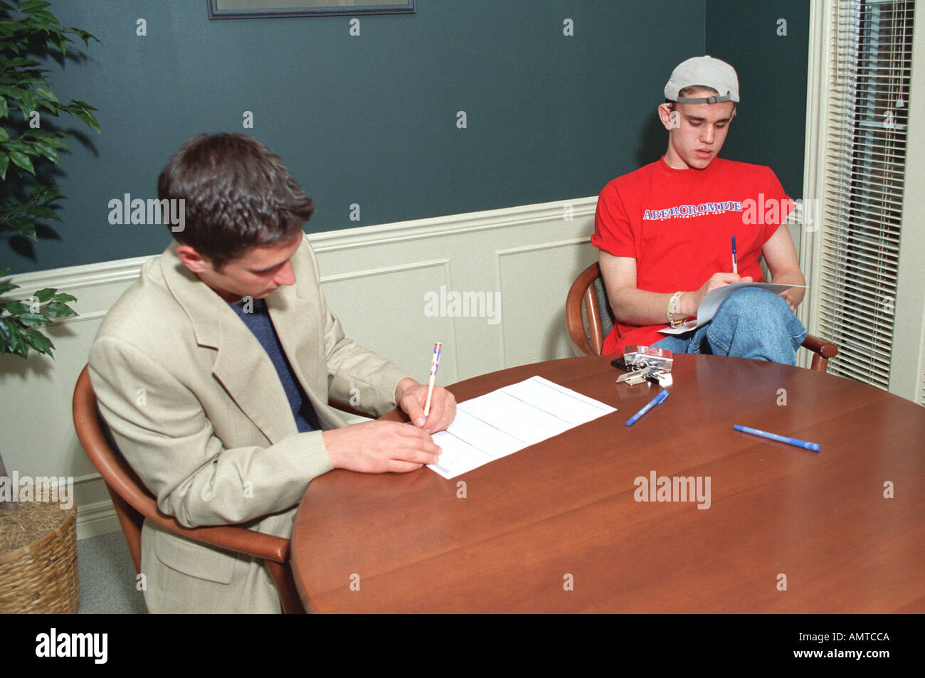 Two job applicants one appropriately dressed one not fill out an ...