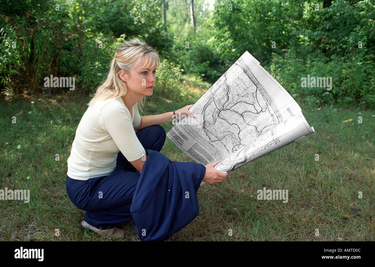 Young female professional land design engineer looks at site plan for a ...