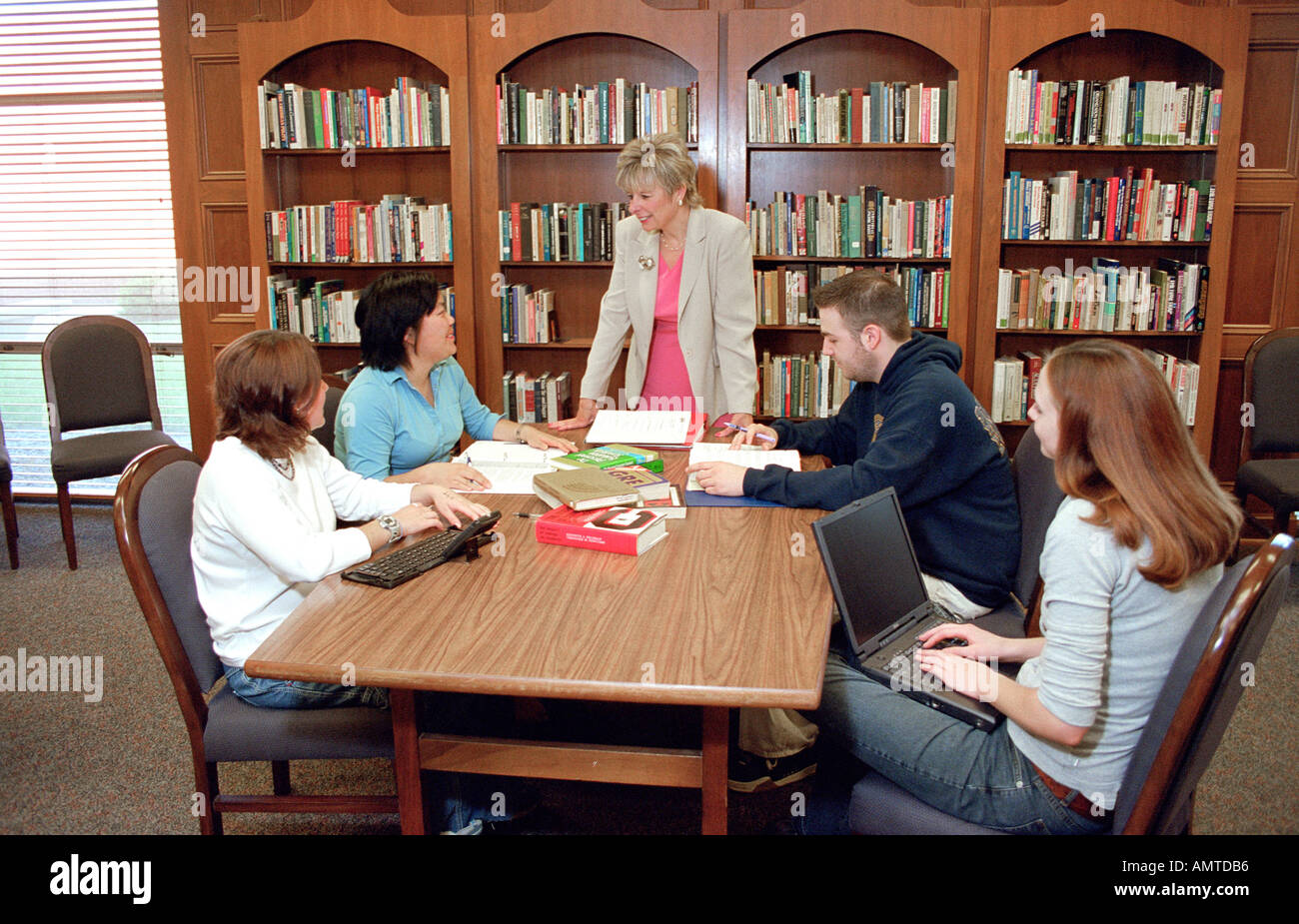 College students work in a group with professor on a research project ...