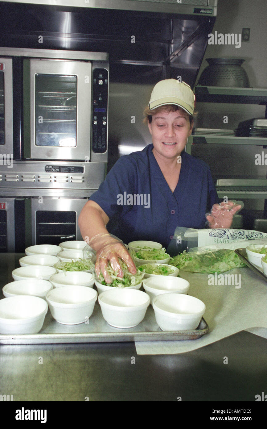Elementary school cafeteria cook prepares salads for students Stock ...