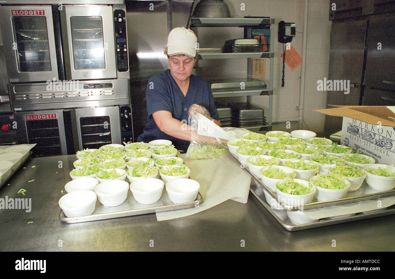 Elementary school cafeteria cook prepares salads for students Stock ...