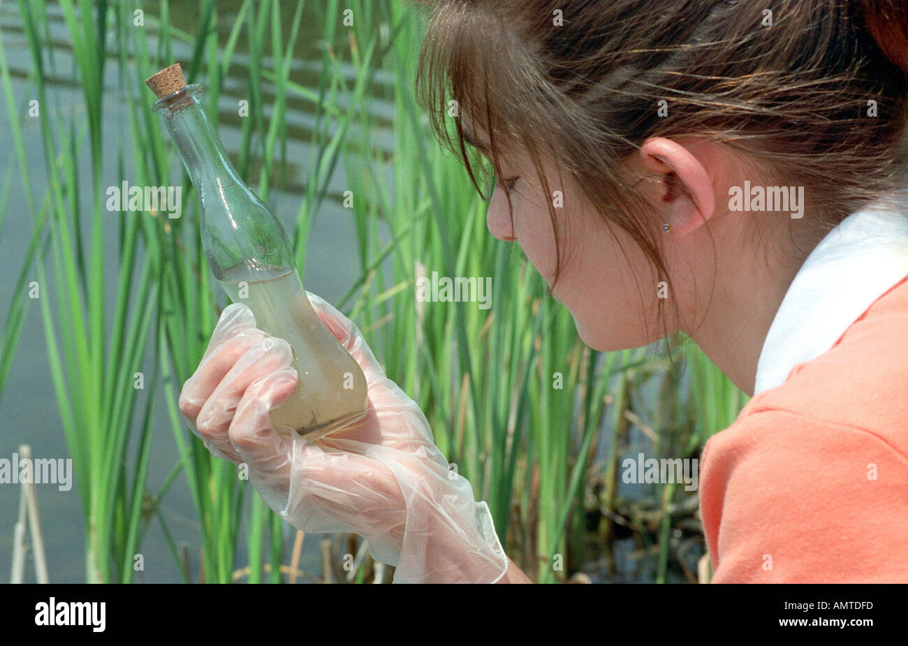 High School student collects muddy water from a pond for water ...