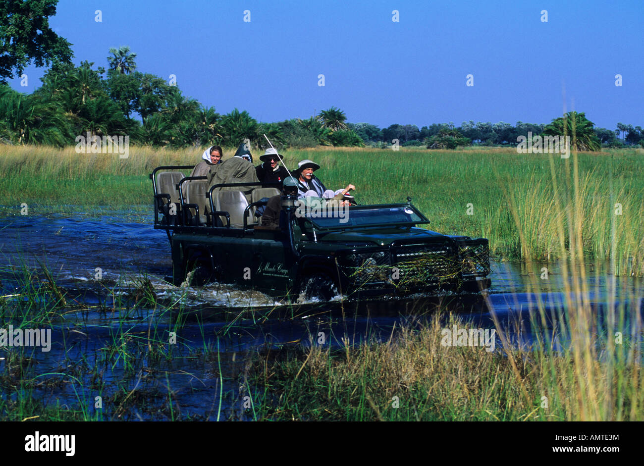 Tourists in game viewing vehicle driving through deep water Stock Photo ...
