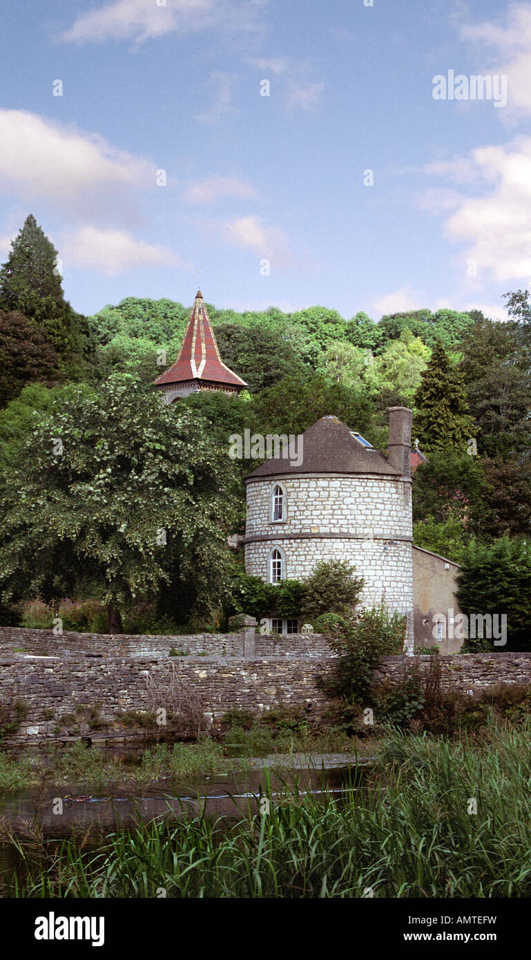 Unusual stone built round house with church tower in surrounding woods ...