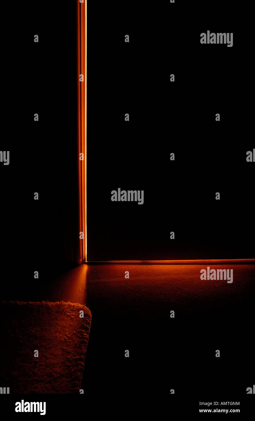 Shaft of light shining under wooden door Stock Photo - Alamy