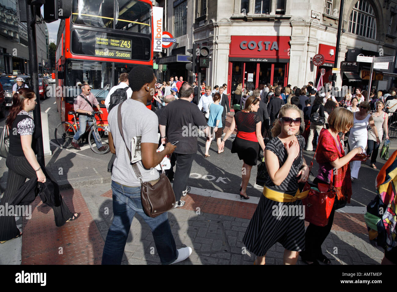 a crowd of people cross at a busy junction at Holborn in London Stock ...
