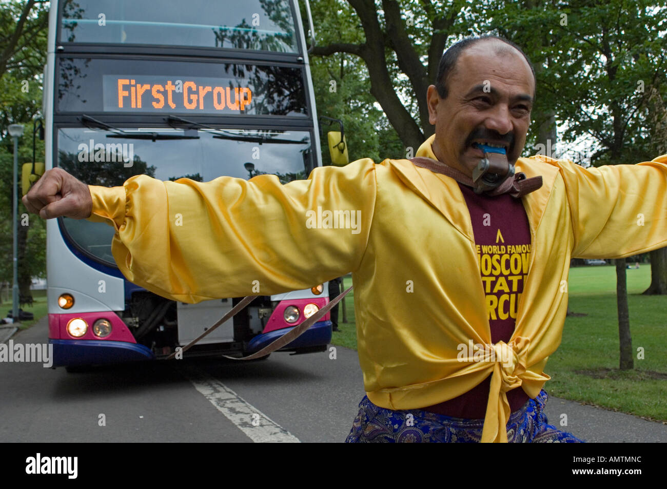 Moscow State Circus strongman towing a double decker bus with is teeth ...