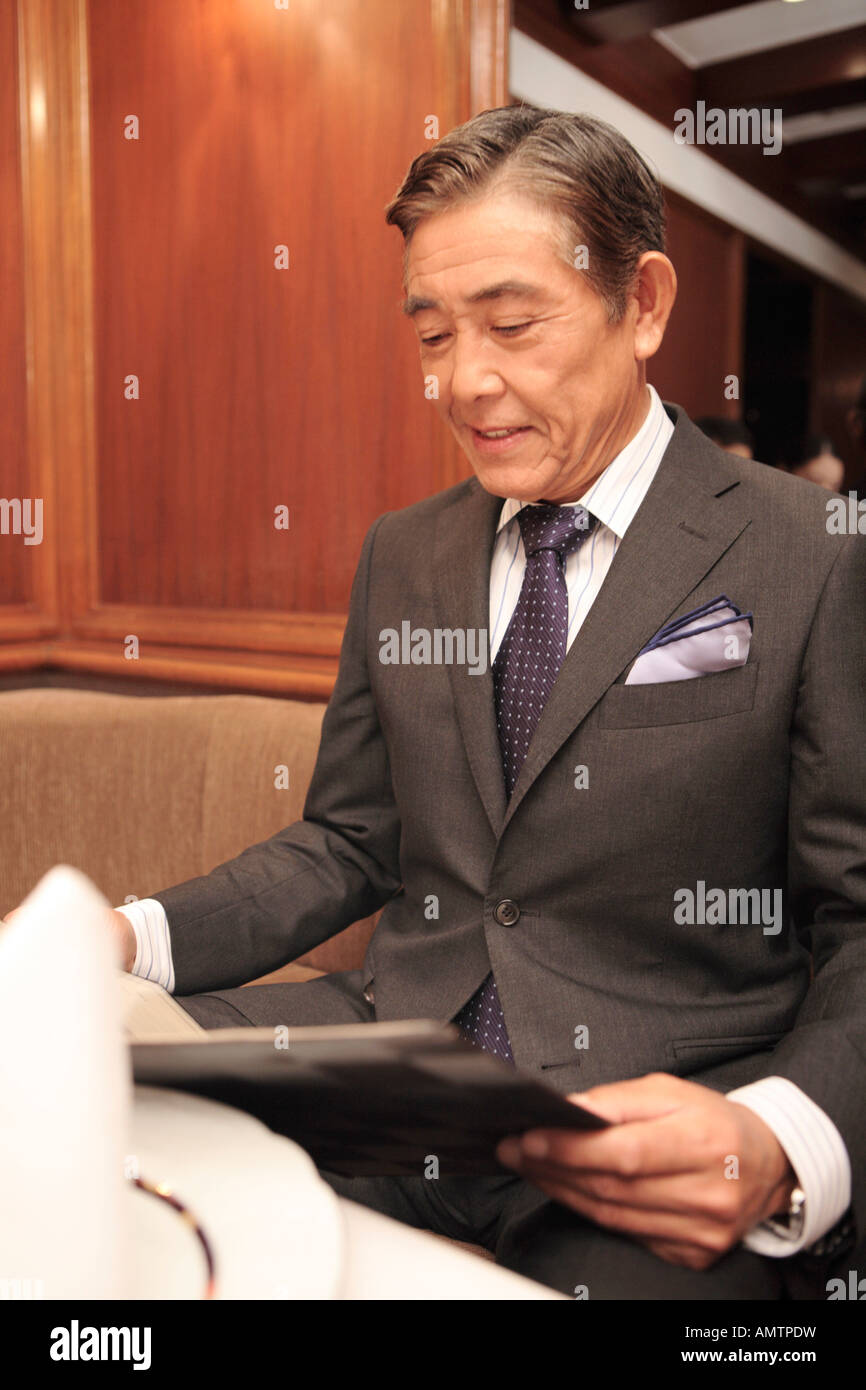 Japanese executive looking at a menu Stock Photo - Alamy