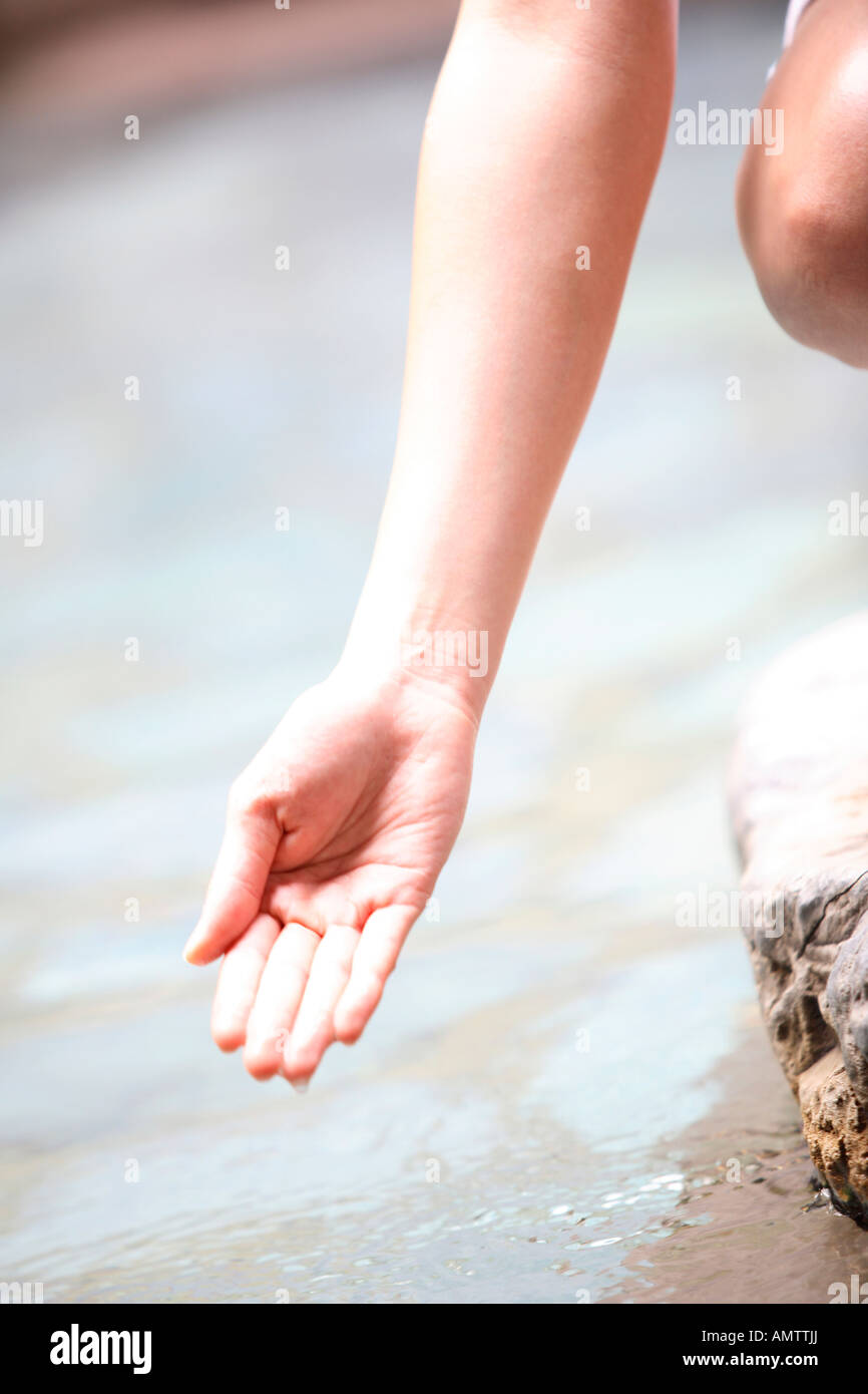 Hand of woman trying to touch hot water Stock Photo - Alamy