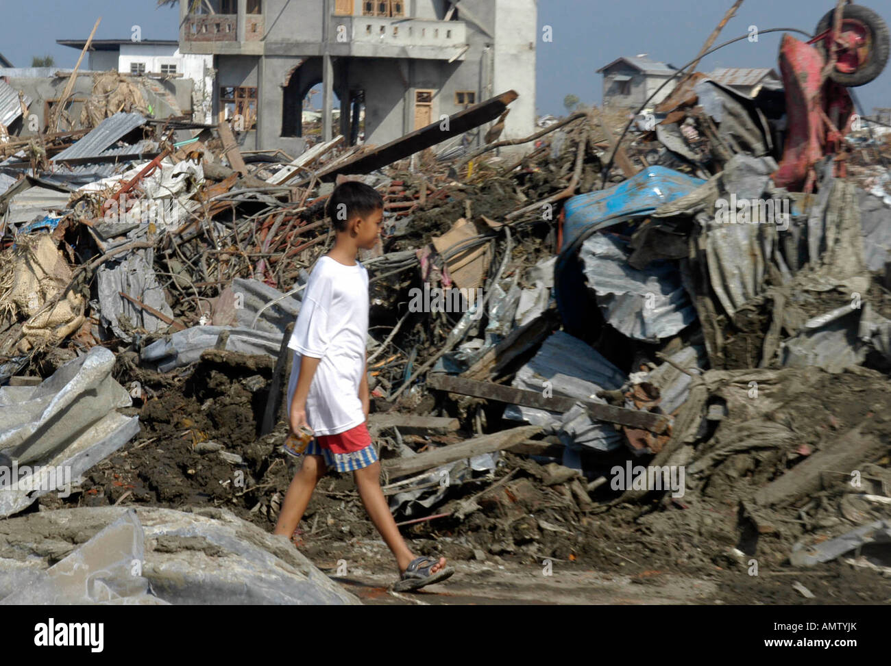 A boy walks through distruction from the Dec 26 Tsunami in Banda Aceh ...
