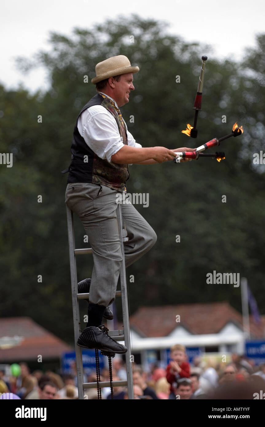 Fire eater on a ladder street performance Stock Photo - Alamy