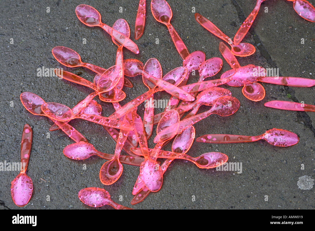 Wet Pink plastic spoons thrown on the pavement Stock Photo - Alamy