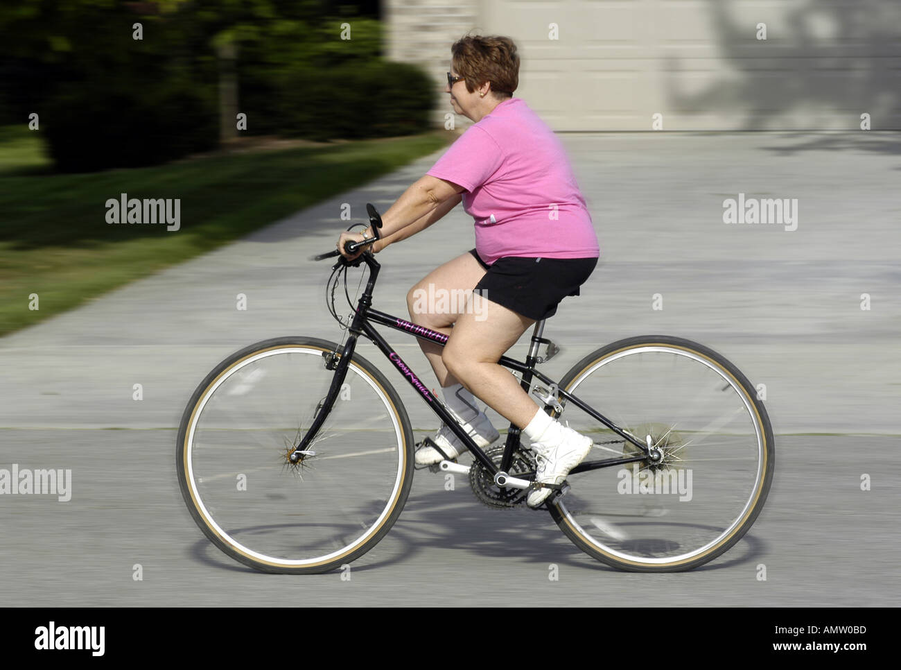 Overweight female rides bicycle for exercise Stock Photo - Alamy