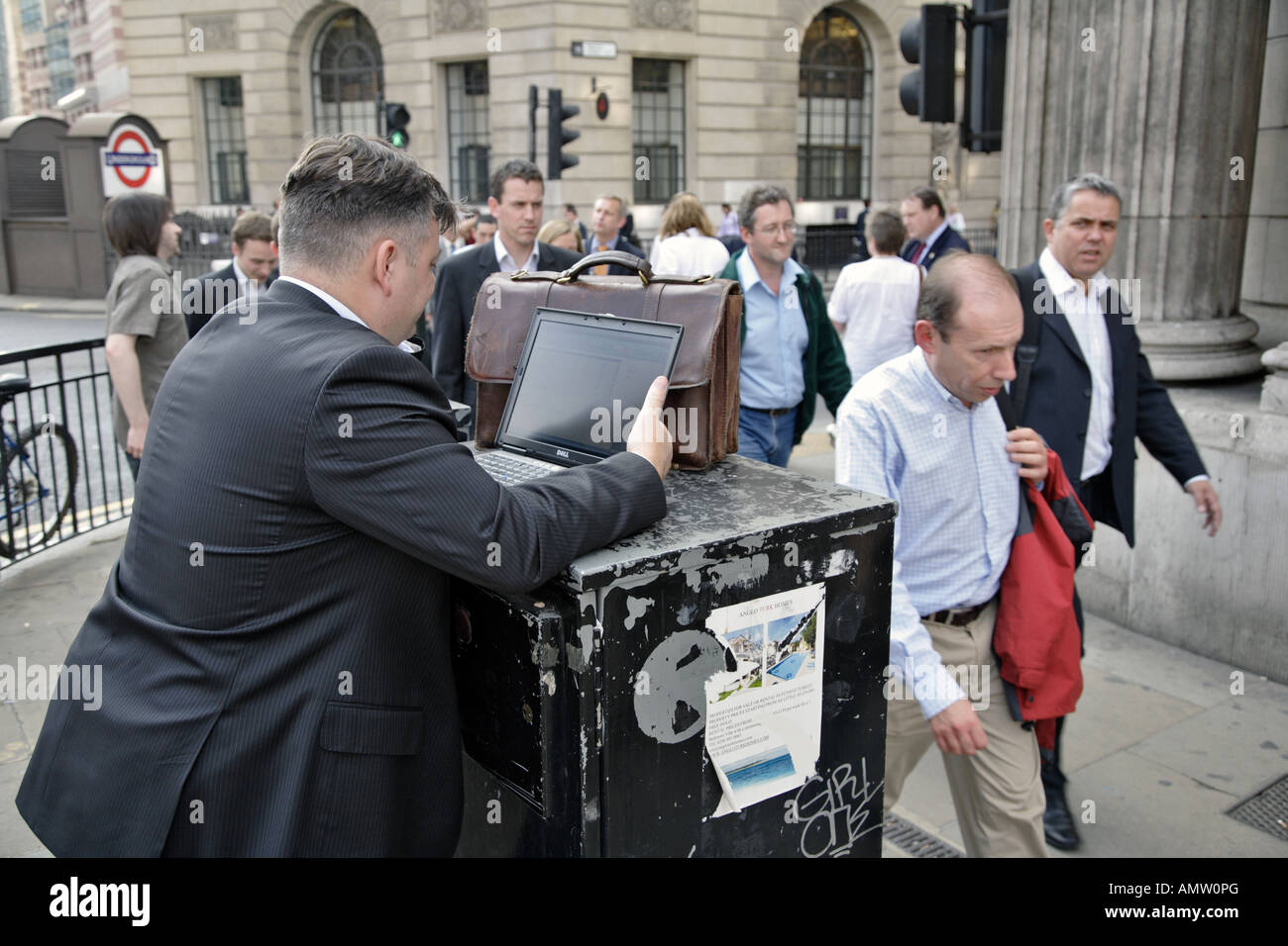 a man uses his laptop outside Bank Station in the City of London Stock ...
