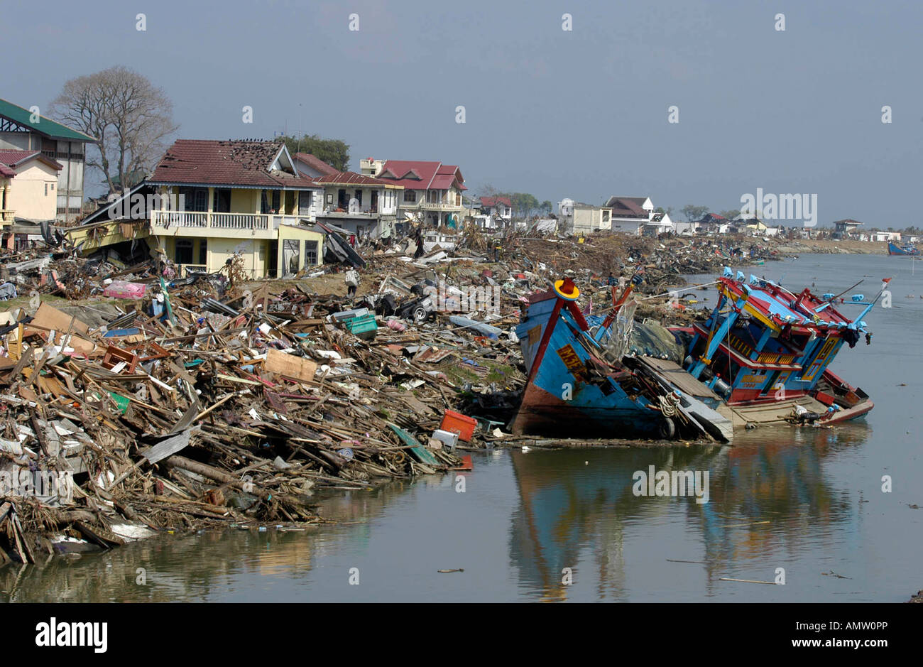 A damaged boat rests next to shore on the Sangai Kreung Aceh River in ...
