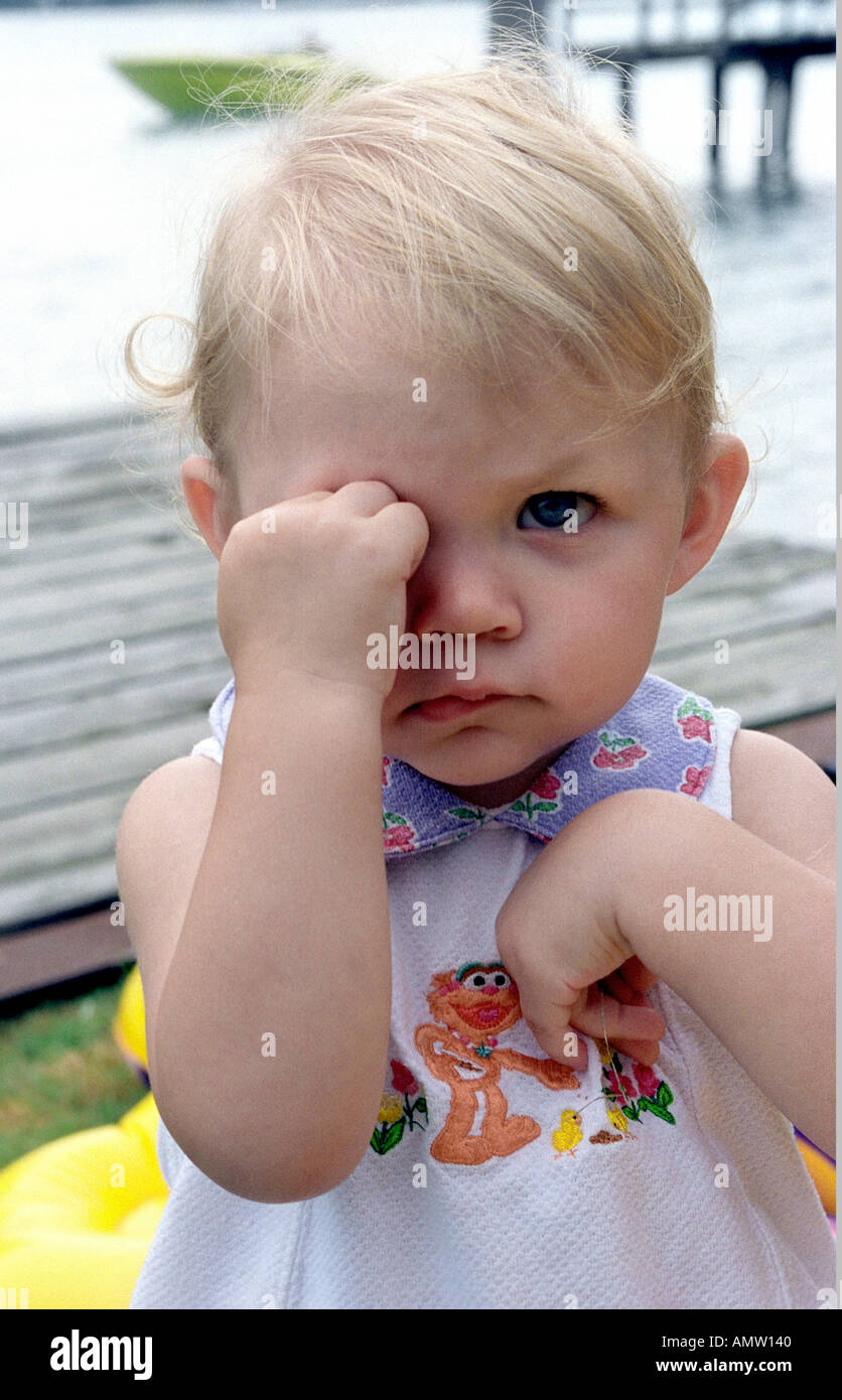 Very tired toddler rubs her eye Stock Photo - Alamy