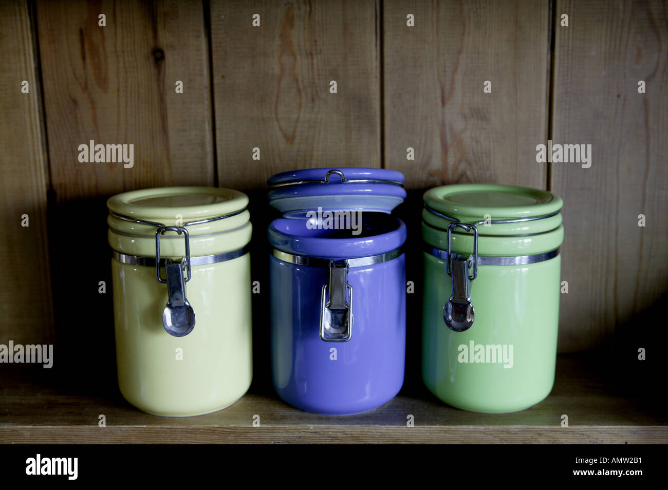 three yellow blue and green container pots on a shelf Stock Photo - Alamy