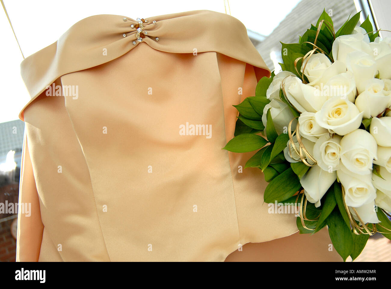 Peach coloured boddice of wedding dress with bouquet of small white ...